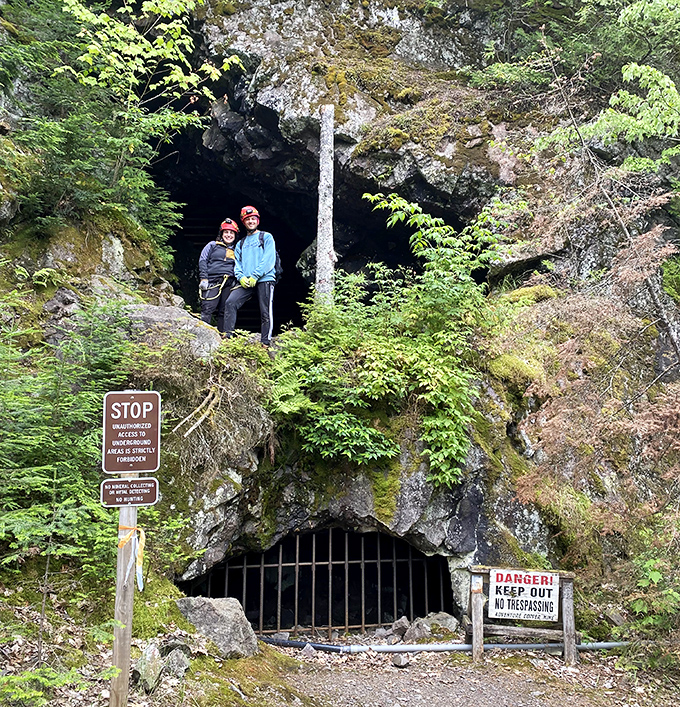 Modern explorers pause at the threshold of history, hard hats ready for the journey into Michigan's copper mining past.