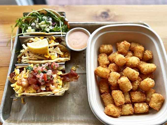 These aren't your average tacos! A trio of handcrafted beauties nestled alongside golden tater tots &ndash; comfort food that graduated with honors.