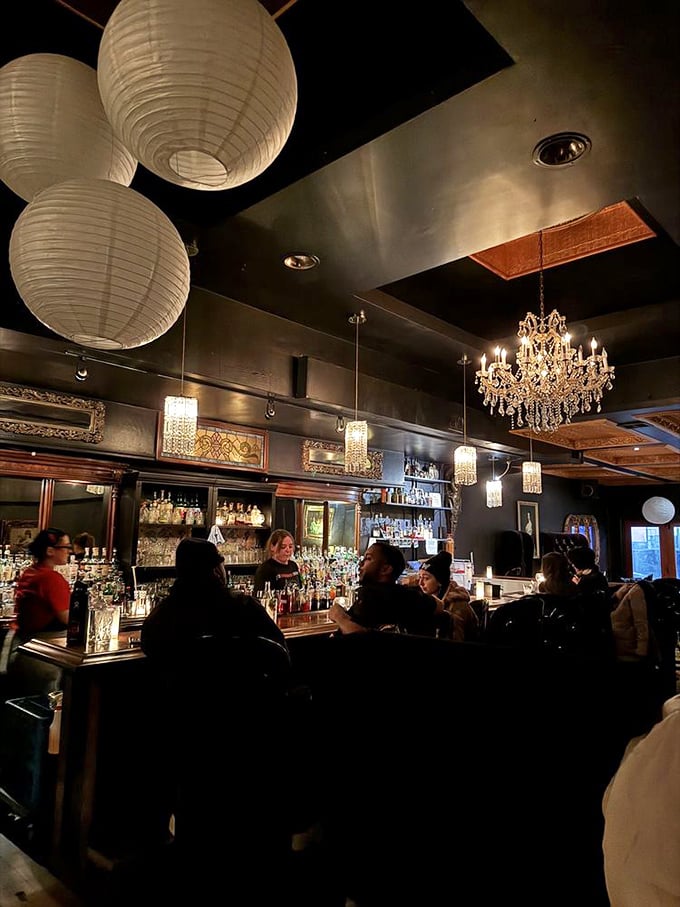 Bartenders work their magic behind a gleaming wooden bar, where bottles stand like soldiers ready for duty in the noble cause of perfect cocktails.