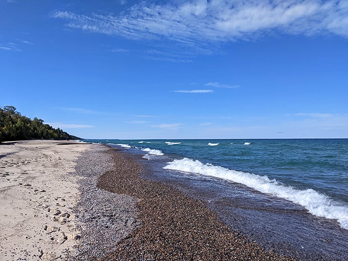 Lake Superior's shoreline plays artist, blending golden sands with polished stones beneath gentle waves.