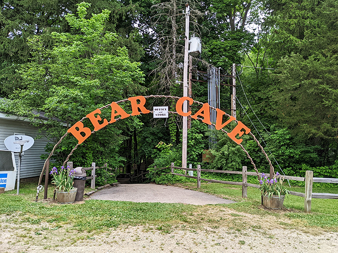 A warm welcome awaits at Bear Cave RV Campground, where a cheerful archway invites visitors into peaceful woods and easygoing Michigan charm.