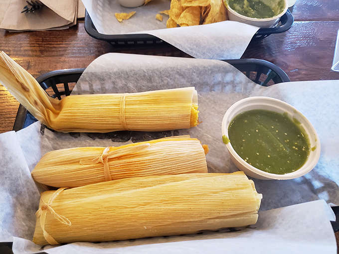 Behold the carnitas tamale in its corn husk wrapper, a humble package containing pork so tender it practically whispers sweet nothings to your taste buds.