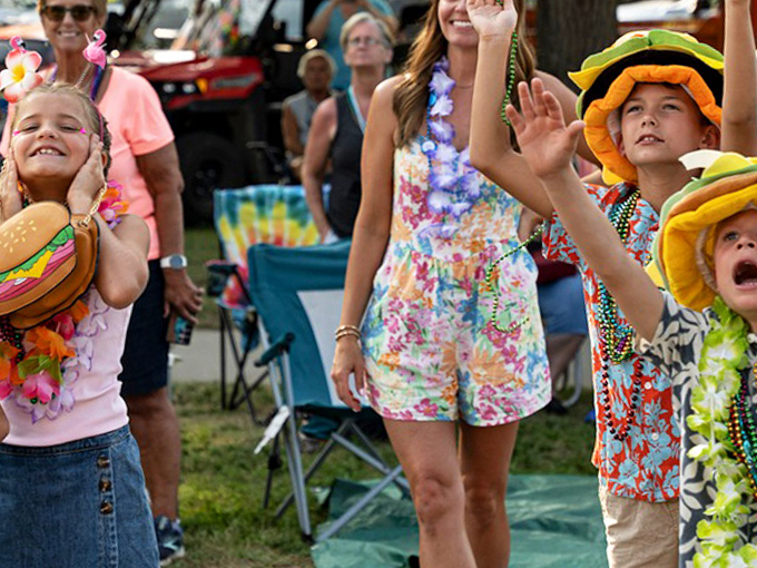 Young burger enthusiasts sport their festival finest, with hamburger hats and Hawaiian accessories completing the required Parrothead-in-training uniform.