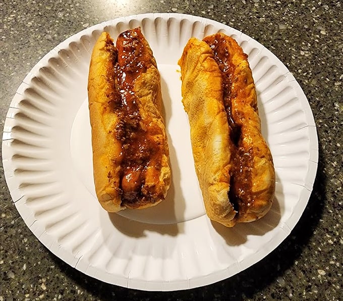 Two perfectly crafted chili dogs on a paper plate &ndash; simple, unpretentious, and absolutely mouthwatering.