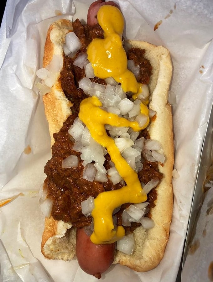 This isn't just any Coney Dog &ndash; it's a masterpiece of snap, savory meat sauce, diced onions, and that perfect yellow mustard zigzag.