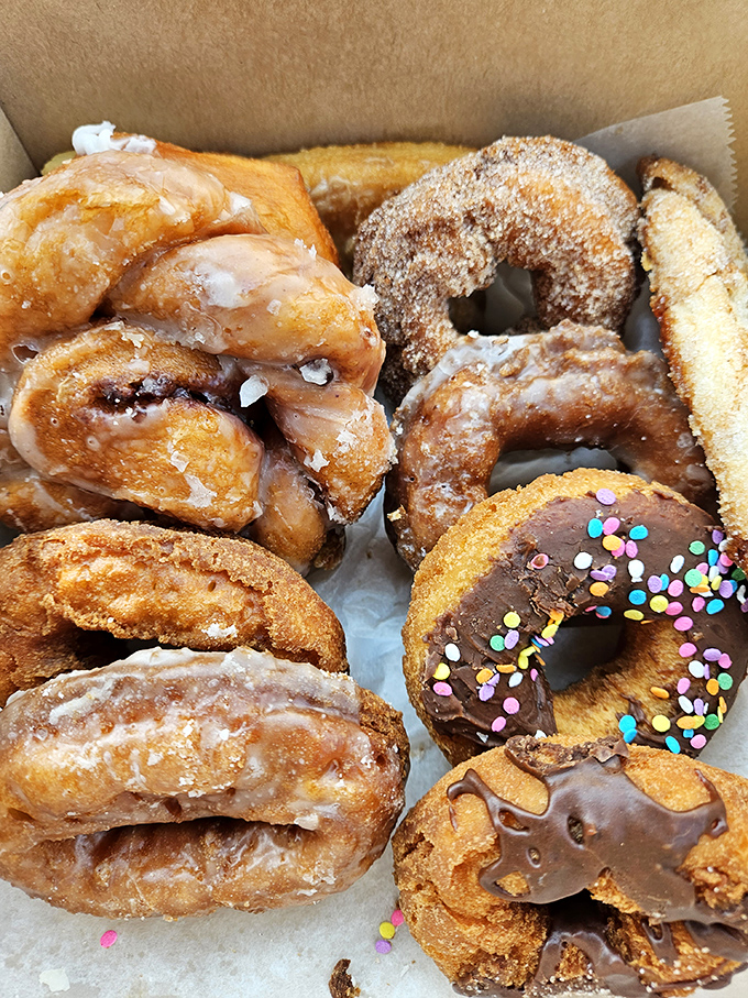 Donut heaven in a box! These golden-brown beauties with their perfect sugar coating are worth every mile of the journey.