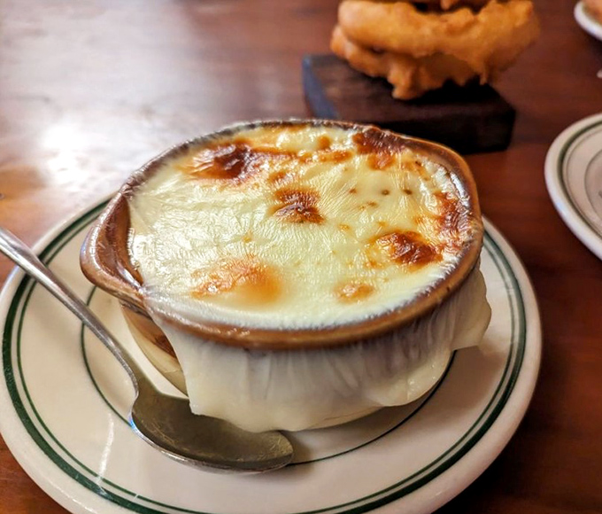 Bubbling cheese blankets rich, deeply flavored broth &ndash; this isn't just French onion soup, it's a religious experience in a crock.