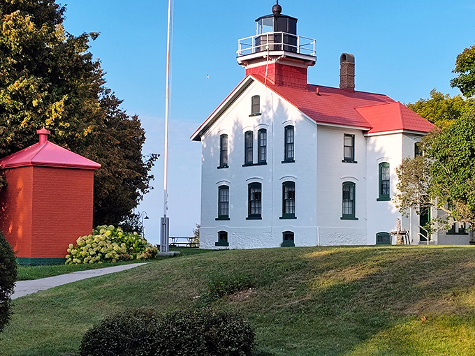 The Grand Traverse Lighthouse stands like a proud maritime sentinel, its red cap visible for miles across the water.