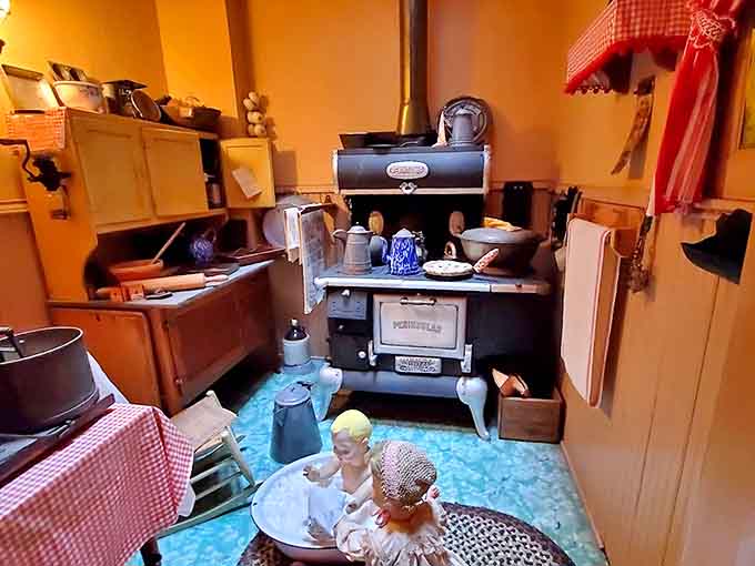 The vintage Porterfield stove anchors this charming kitchen exhibit, where blue linoleum and red checkered curtains transport visitors to grandma's era.