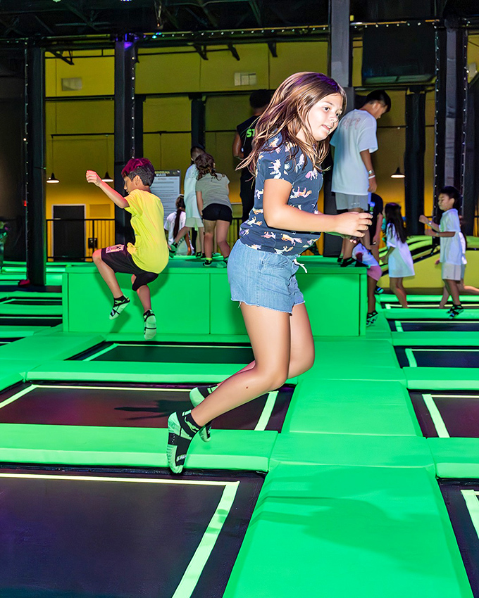 Mid-air magic happens as jumpers navigate the trampoline grid, each bounce propelling them higher than their last leap.
