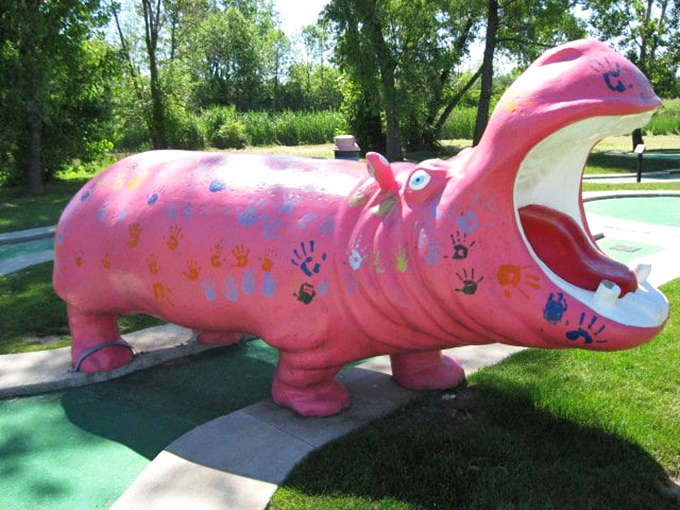 This pink hippo sculpture, decorated with colorful handprints, has witnessed countless mini-golf victories and defeats while maintaining its perpetually hungry grin.
