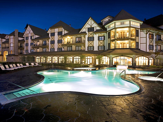 The resort's outdoor pool glows with an ethereal blue light at dusk, reflecting the impressive fa&ccedil;ade of the Mountain Grand Lodge.