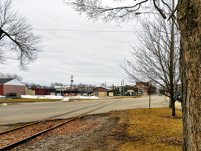 Railroad tracks stretch toward the horizon, a reminder that small towns weren't built by accident but by iron paths connecting distant dreams.