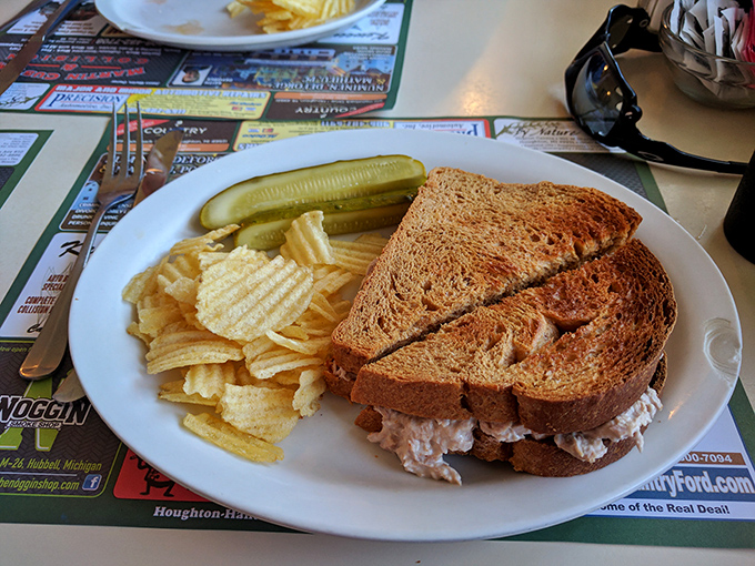 The Reuben sandwich arrives piled high with corned beef and melted Swiss, proving that sometimes the classics become classics for very good reasons.