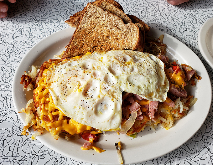 Skillet Hashed Browns: a mountain of crispy-outside, tender-inside potatoes topped with sunny eggs that break into liquid gold at the touch of a fork.