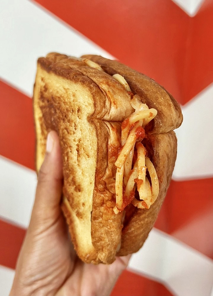 Carb-on-carb perfection: spaghetti embraced by golden garlic toast creates a handheld masterpiece that defies tradition and delights taste buds.