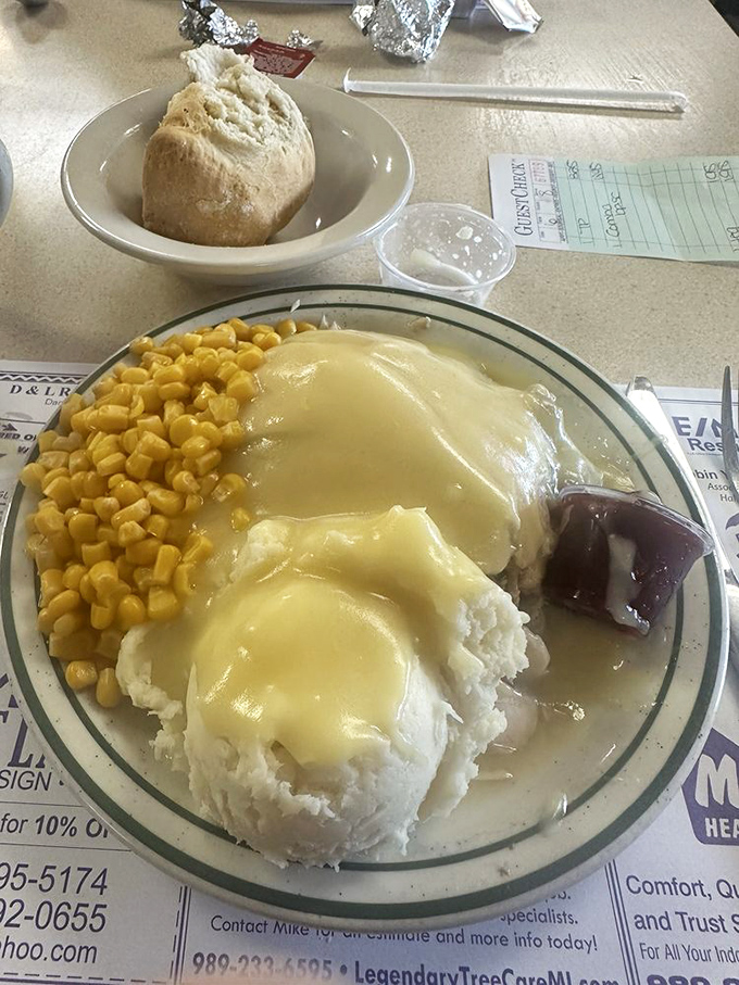 Turkey dinner perfection on a plate &ndash; tender slices bathed in gravy alongside mashed potatoes, sweet corn, and that essential touch of cranberry.