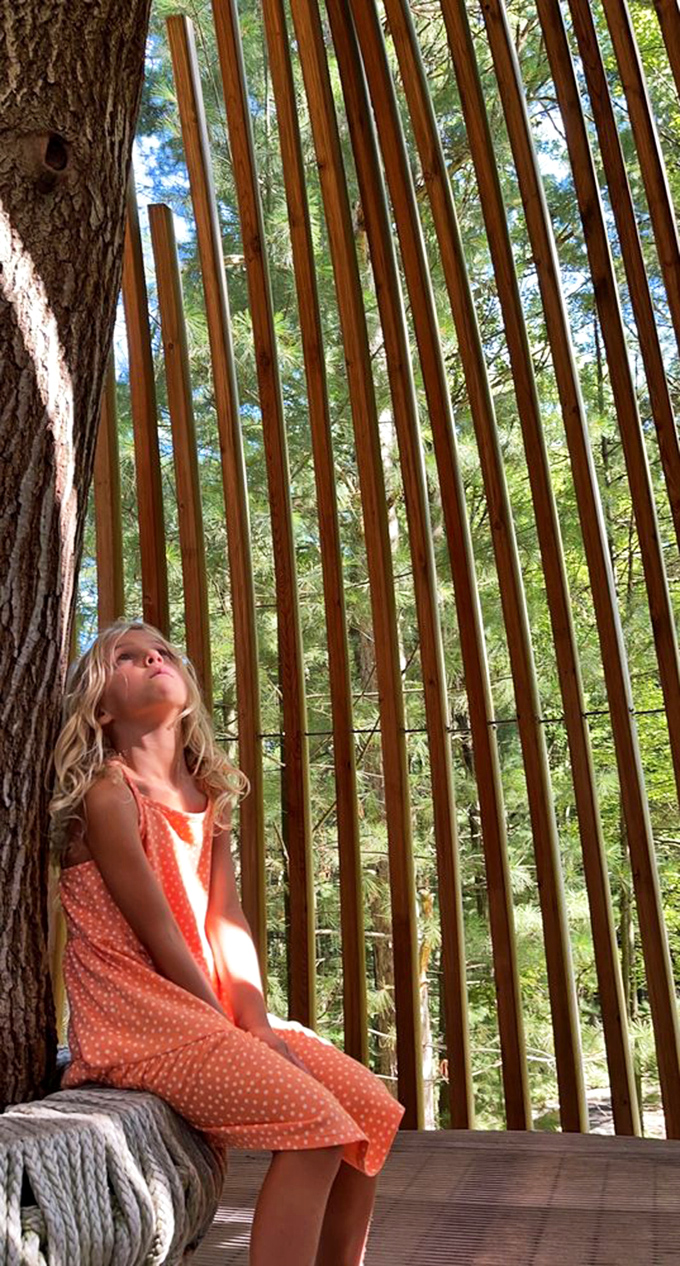 Wooden slats frame this moment of childhood wonder, where nature becomes the most captivating playground imaginable.