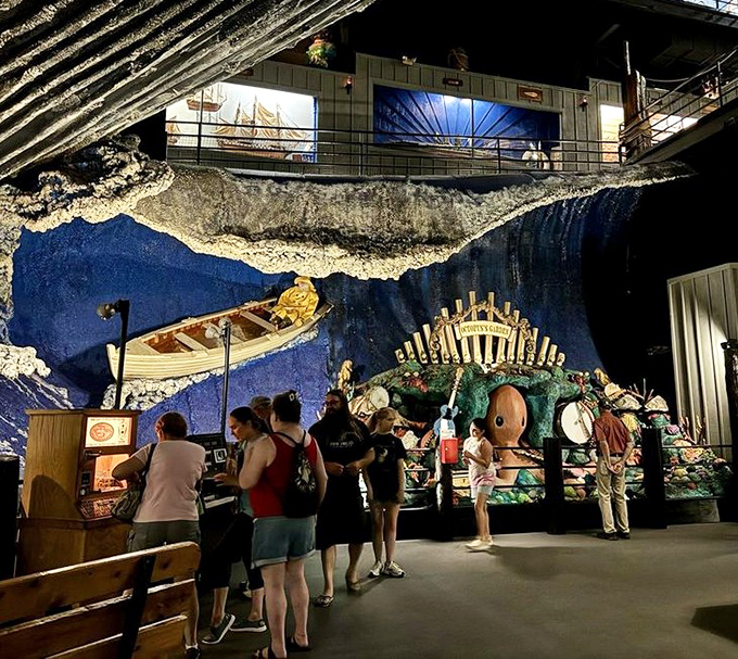 Visitors stand mesmerized before an elaborate oceanic display, where a massive sea creature battles a giant squid in a maritime fever dream.