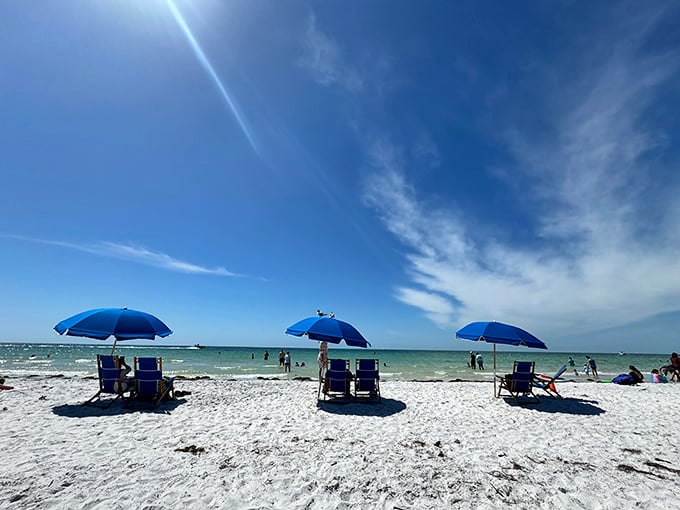 Beach chairs await under vibrant blue umbrellas &ndash; front-row seats to nature's greatest show without the Hollywood price tag.