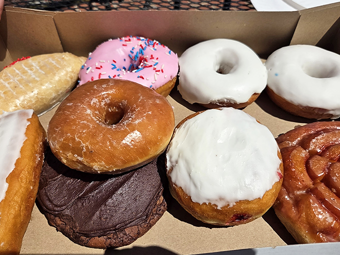 A box of evidence: assorted donuts showcase the bakery's range, from classic glazed to chocolate-dipped and sprinkle-topped confections.