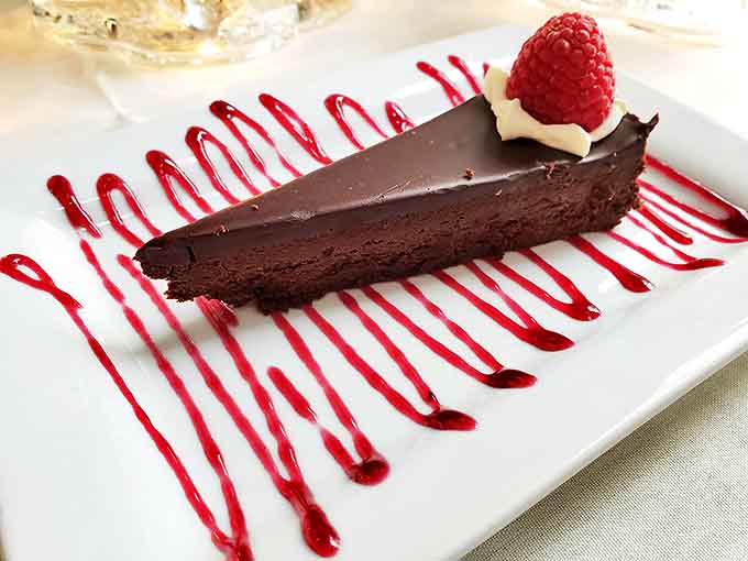 Chocolate decadence that would make Willy Wonka jealous &ndash; this flourless torte with raspberry accent delivers pure, unadulterated bliss on a plate.