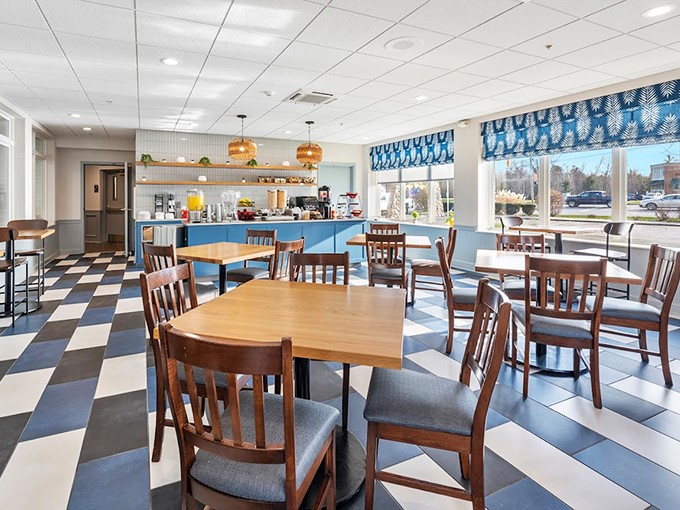 Morning sunshine streams through blue-trimmed windows while checkerboard floors set the stage for breakfast that fuels lake adventures.