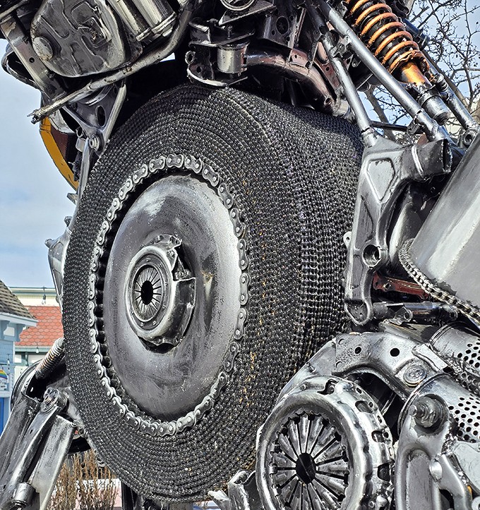 Look closely and you'll spot intricate mechanical details like this repurposed flywheel, showcasing the meticulous craftsmanship that went into creating this metal behemoth.