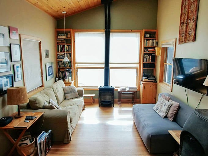 Warm wood paneling and large windows transform this living space into a cozy observatory for nature's ever-changing lakeside show.