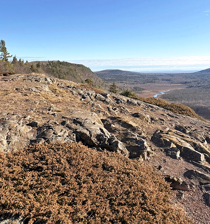 Rocky outcroppings stand sentinel over the valley, offering hikers front-row seats to a panorama millions of years in the making.
