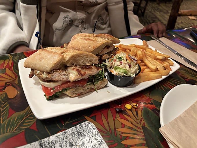 This sandwich arrives stacked higher than your expectations, accompanied by fries that actually deserve to share the plate with it.