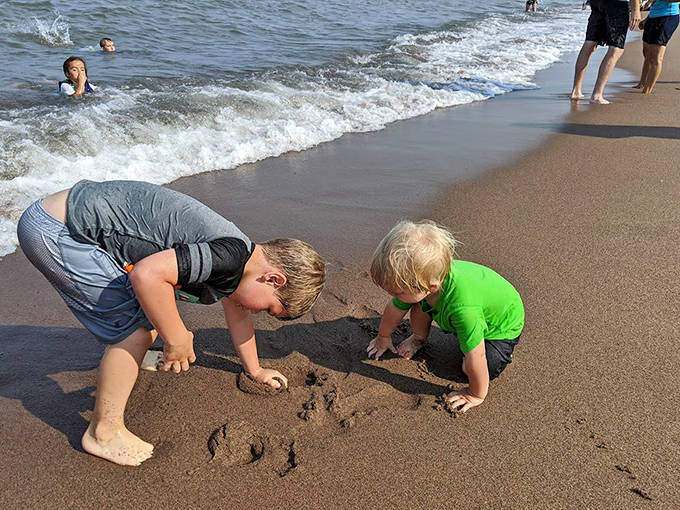 Childhood joy in its purest form &ndash; little hands discover the simple pleasure of digging in cool, wet sand at the water's edge.