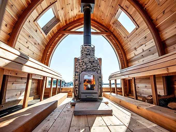 The heart of the experience: a stone-surrounded wood stove crackling with ancient wisdom, transforming simple firewood into soul-warming therapy.