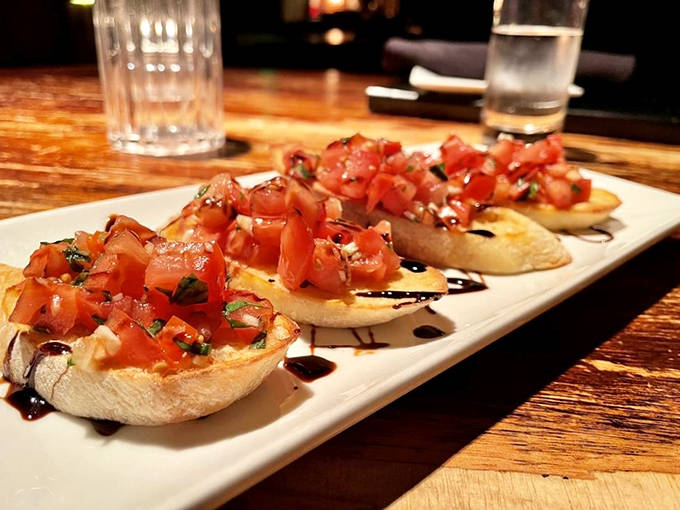 Bruschetta: Simple perfection on toasted crostini – vibrant tomatoes and fresh basil drizzled with balsamic reduction that's worth every delicious bite.