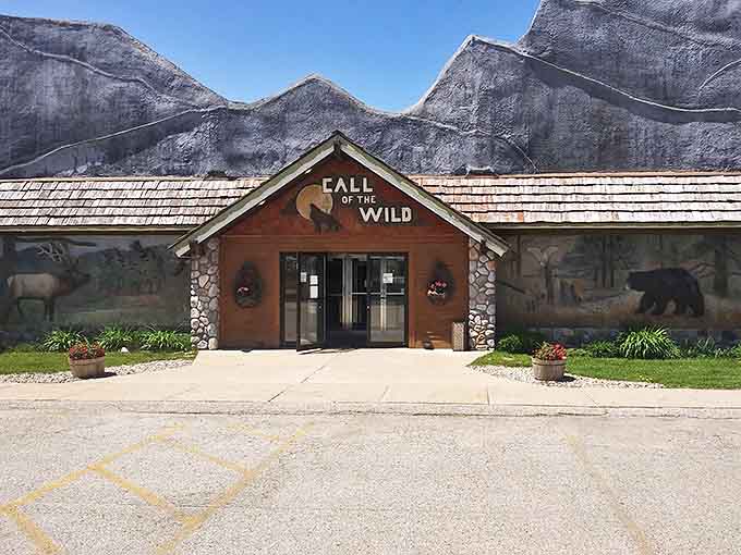 The Call of the Wild Museum in Gaylord welcomes nature enthusiasts with its rustic log cabin exterior and dramatic mountain backdrop. Inside awaits Michigan's wildlife in stunning detail.