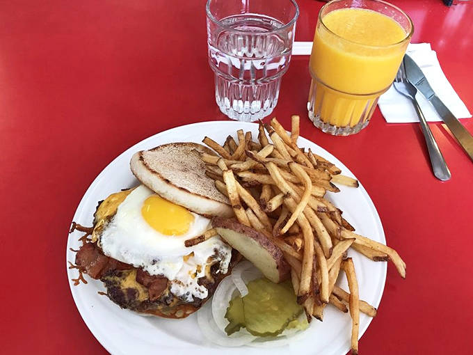 Breakfast meets burger in this morning masterpiece – a sunny-side-up egg crowns the patty like a yellow halo of deliciousness.