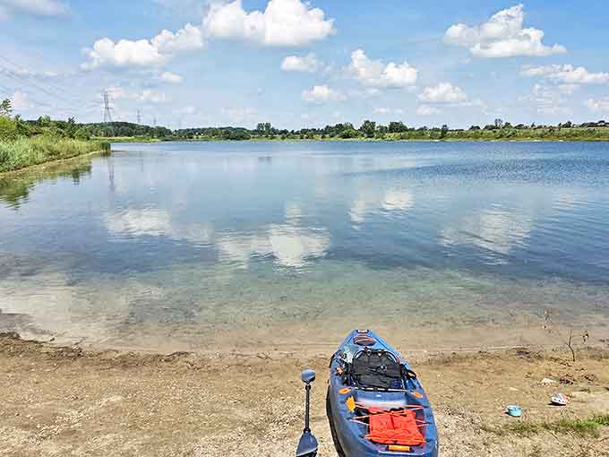 A lone kayak waits at the shoreline, promising adventures on crystal waters where time slows to the rhythm of gentle paddling.