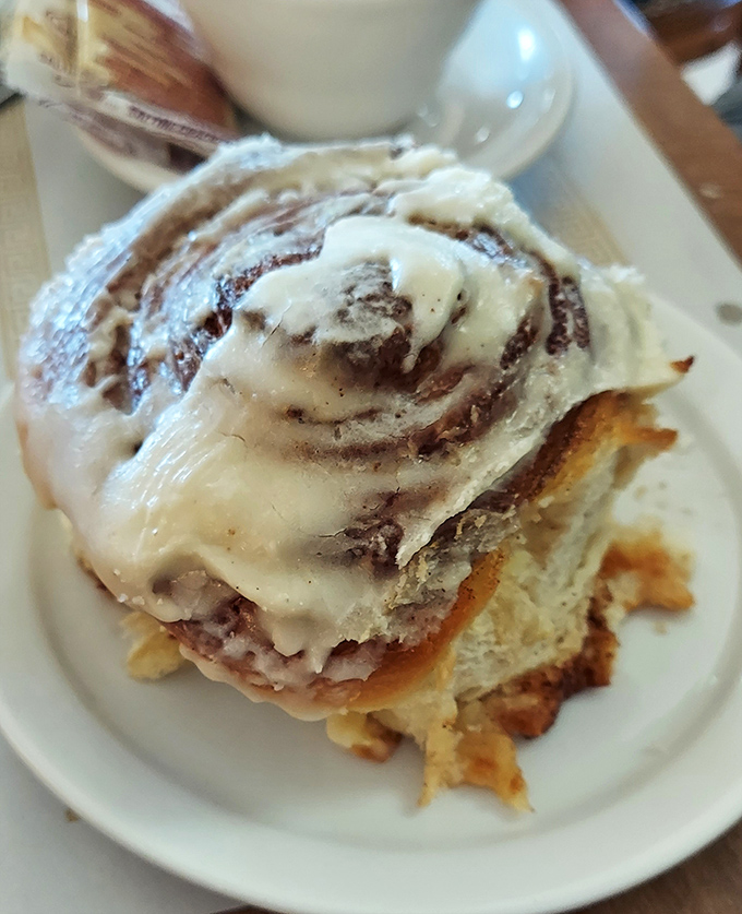 Behold the cinnamon roll that launched a thousand road trips, generously glazed and swirled to absolute perfection, basically edible happiness on a plate.
