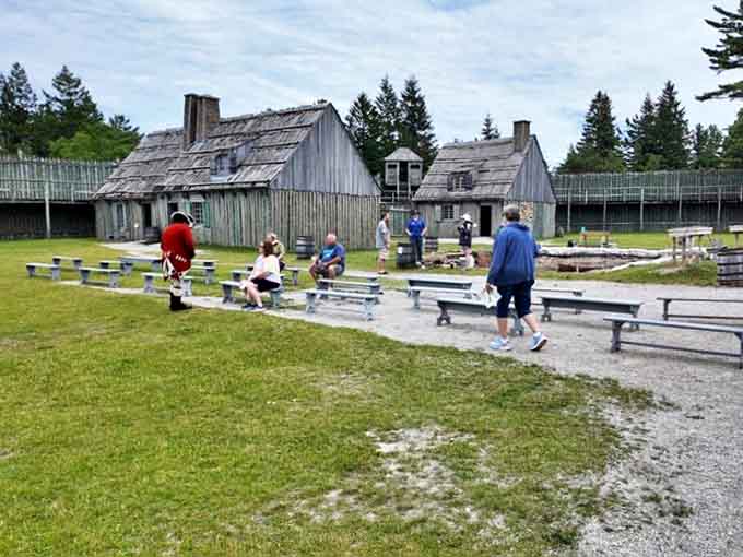 History's audience: Visitors gather on simple wooden benches, momentarily trading their modern comforts for an authentic glimpse into colonial hardships.