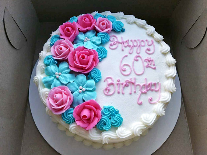 Happy 60th indeed! This celebration cake showcases the bakery's artistic touch with its perfect pink roses and blue accents &ndash; almost too pretty to cut.