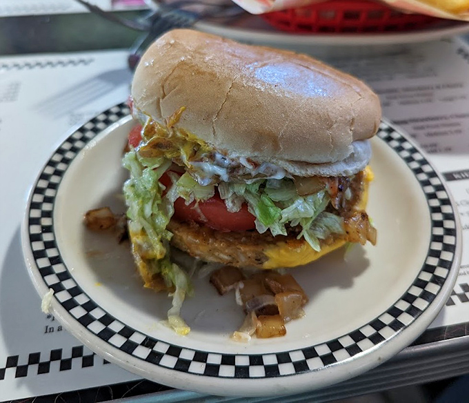 The deluxe cheeseburger arrives dressed to impress with crisp lettuce, ripe tomato, and melty cheese in perfect harmony.