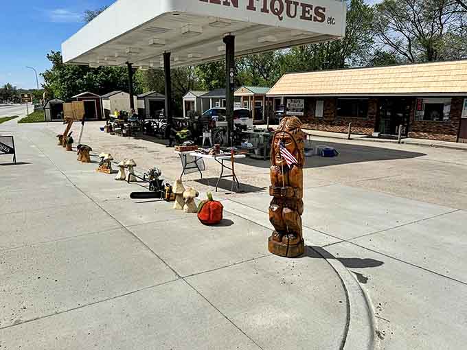 Prairie Mercantile Antique Store spills its treasures onto the pavement, where wooden carvings stand guard over vintage finds waiting to be discovered.