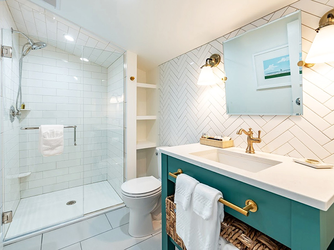 Guest Bathroom: Herringbone tile meets brass fixtures in this bathroom that somehow makes you want to renovate your entire home after your vacation.
