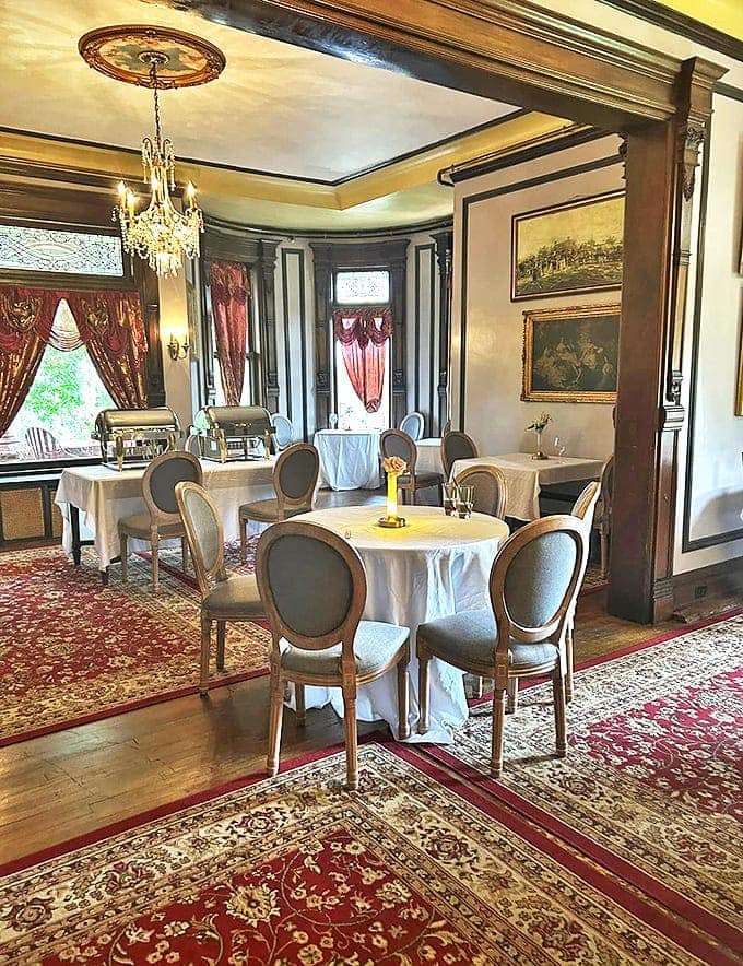 Dining Room: Elegant place settings await beneath crystal chandeliers, where fine dining meets Victorian splendor in a room that whispers of lavish dinner parties past.