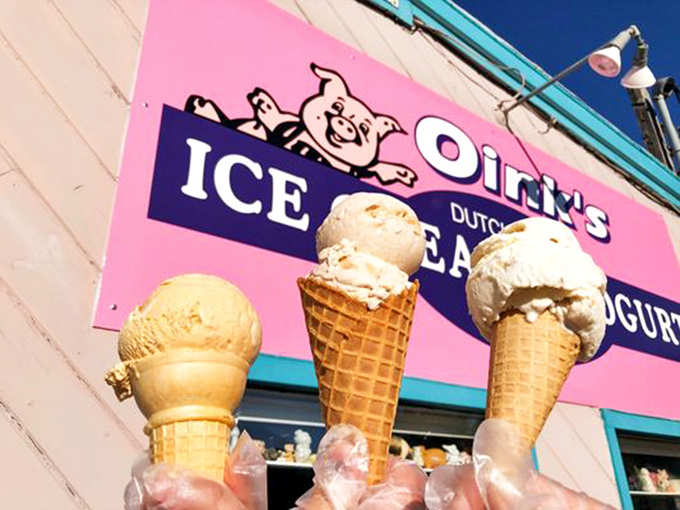 Three perfect scoops standing tall against the Oink's sign &ndash; a triumphant tower of frozen delight ready for its moment of glory.