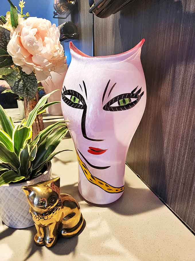 That pink Kosta Boda vase isn't just giving side-eye &ndash; it's judging your entire living room decor choices from its perch.
