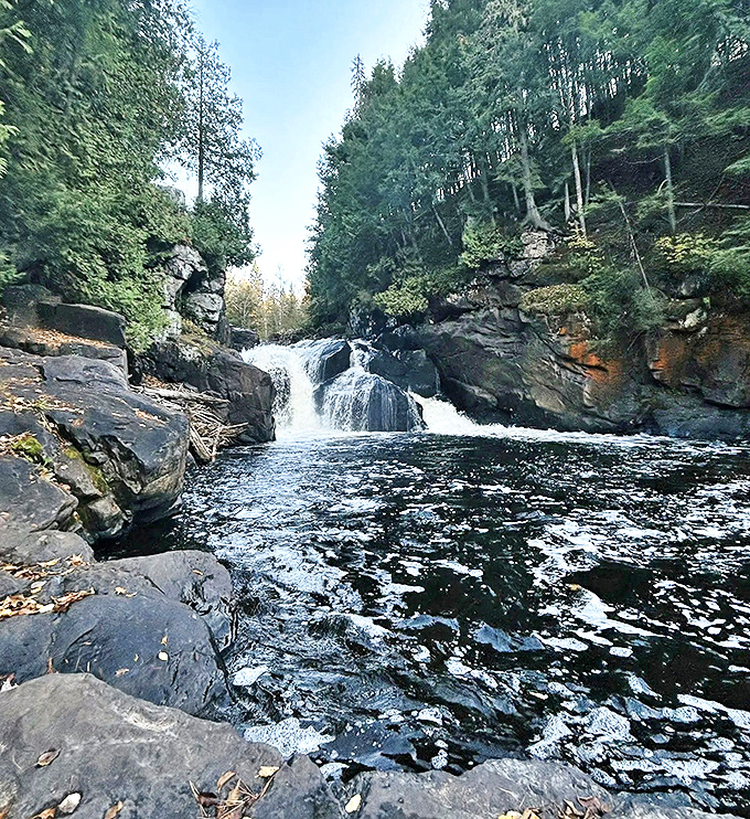 The reward awaits: Crystal clear waters gather in a natural pool below the lower cascade, inviting weary hikers to pause and reflect.