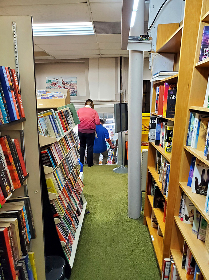 Narrow pathways between towering shelves create an intimate treasure hunt experience, where literary gems hide around every corner.