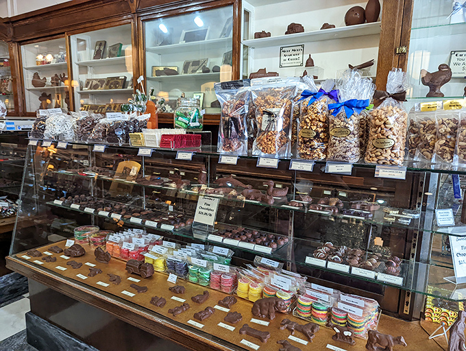 Behind gleaming glass, chocolate-enrobed treasures and perfectly roasted nuts stand at attention – edible jewels crafted by hands that understand patience and precision.