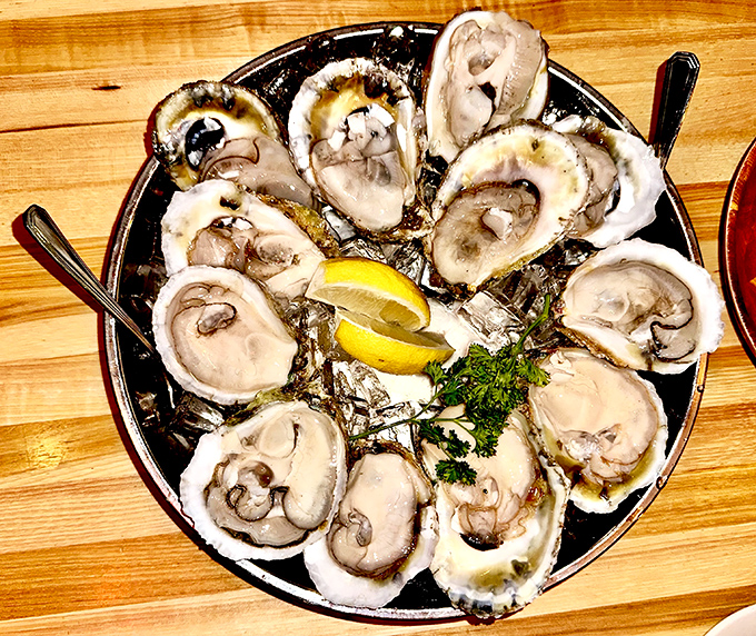 Fresh oysters glisten on ice like jewels, each one a perfect briny bite of ocean bliss.